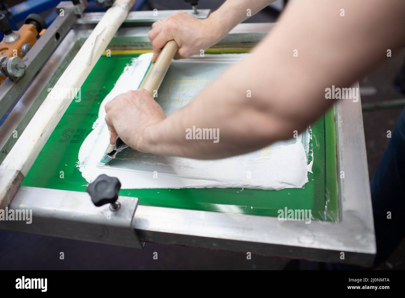 Serigraphy silk screen print process at clothes factory. Frame ...