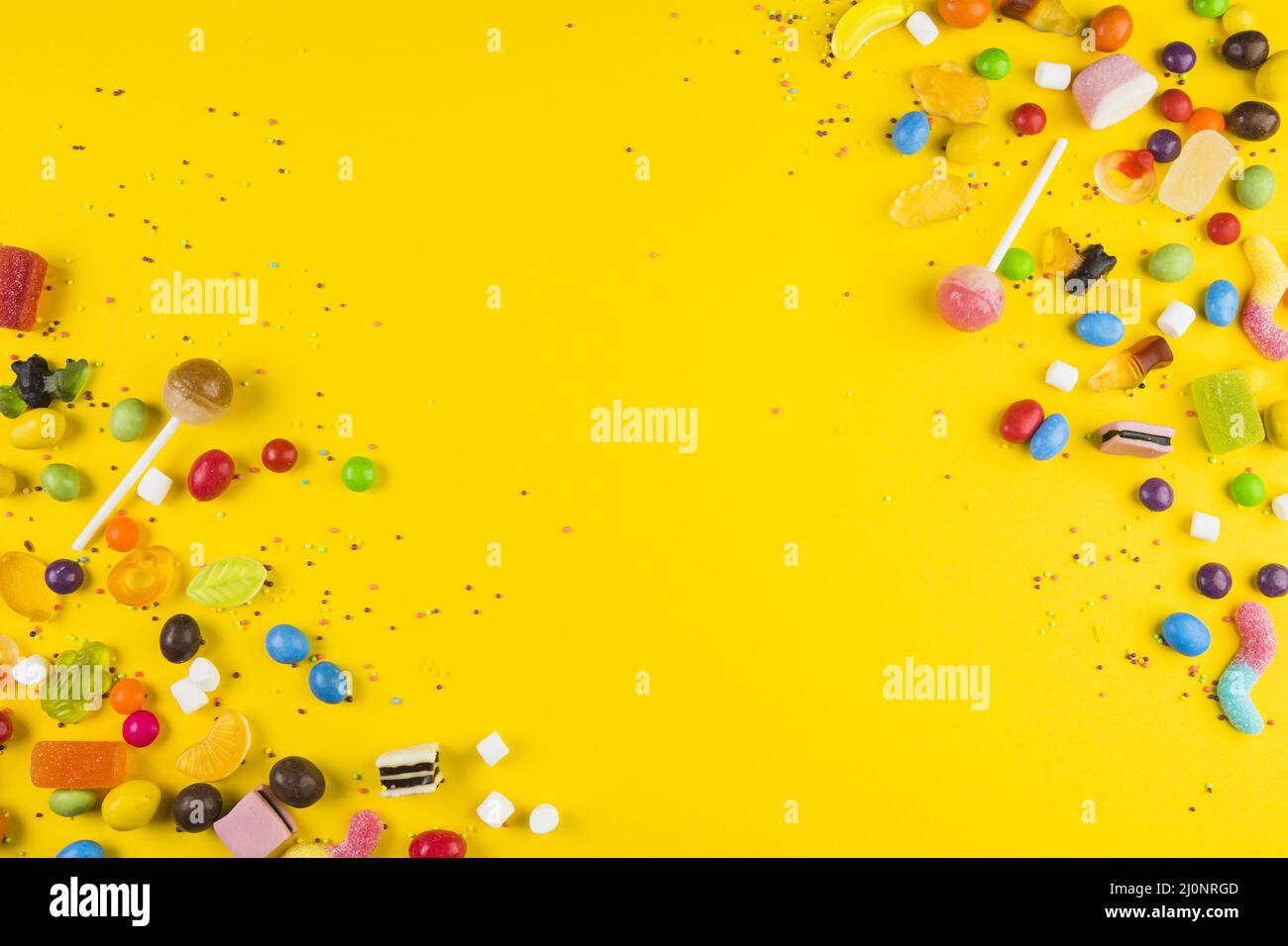 Various colorful candies lollipops yellow surface. High quality and ...