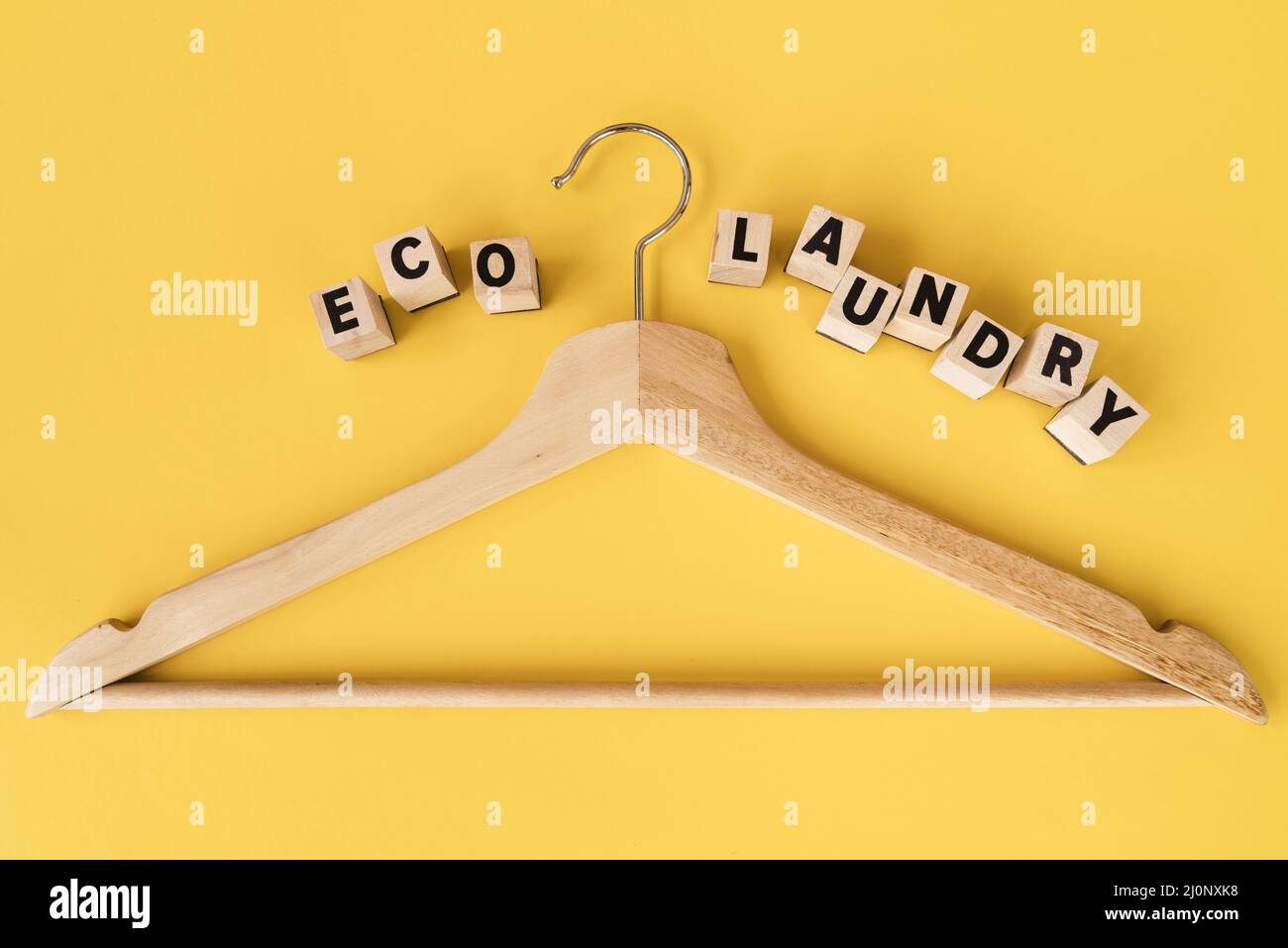 Top view wooden hanger with yellow background. High quality and ...