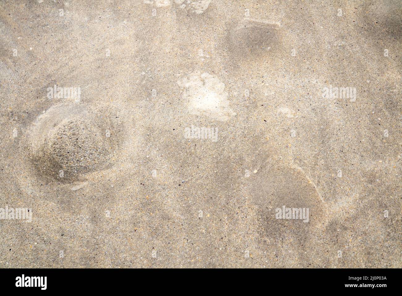 Bubbles in the sand showing that the tide is coming in Stock Photo - Alamy
