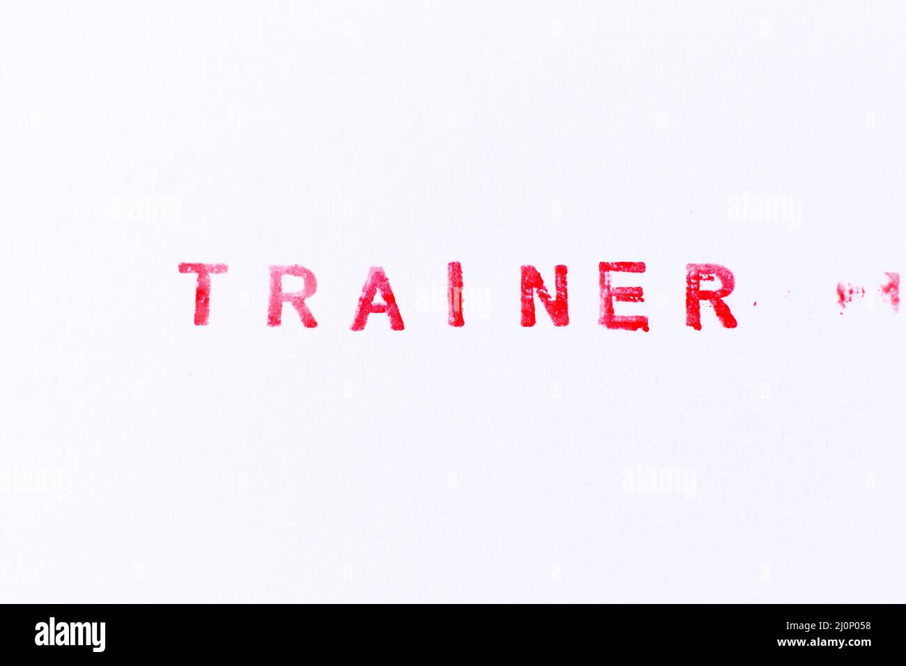 Red color ink rubber stamp in word trainer on white paper background ...