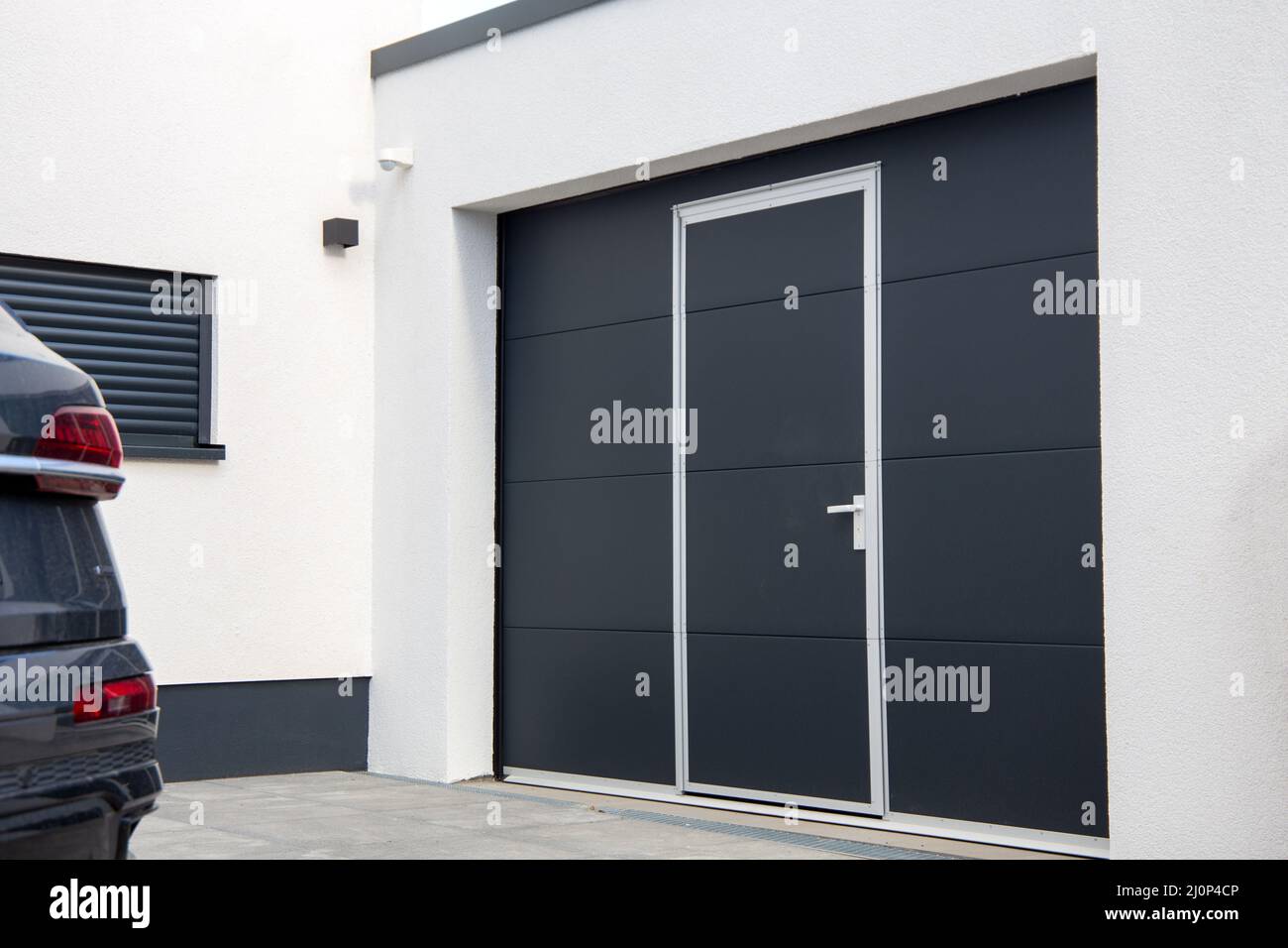 Modern new garage door (sectional door) with door Stock Photo - Alamy