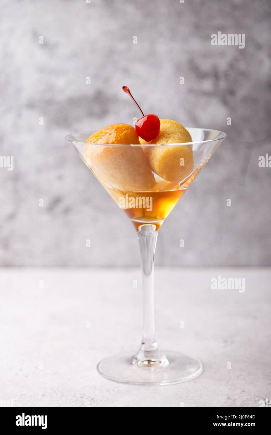 Neapolitan Rum baba (or baba au rum) in a martini glass with a cocktail ...