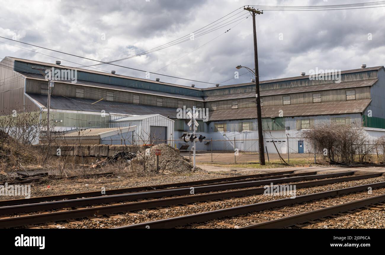 An old warehouse next to train tracks and a crossing in Braddock ...