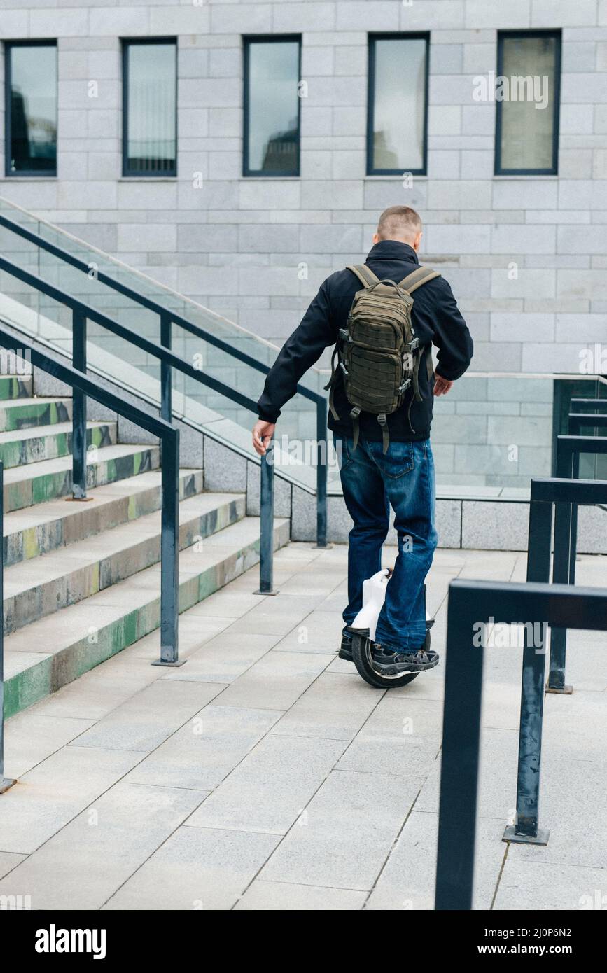 Man riding fast on electric unicycle on city street. Mobile portable ...