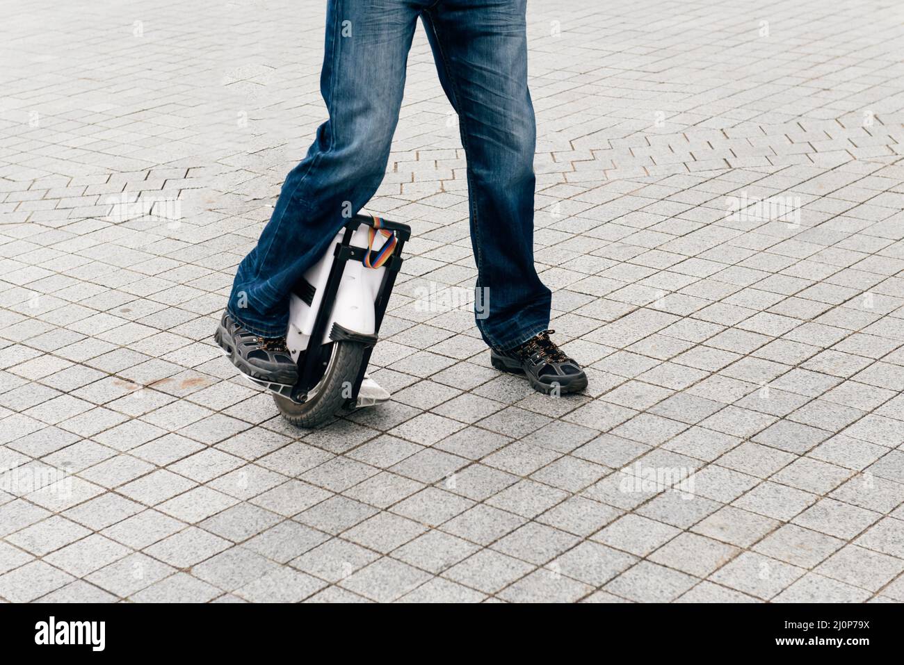 Man riding fast on electric unicycle on city street. Mobile portable ...
