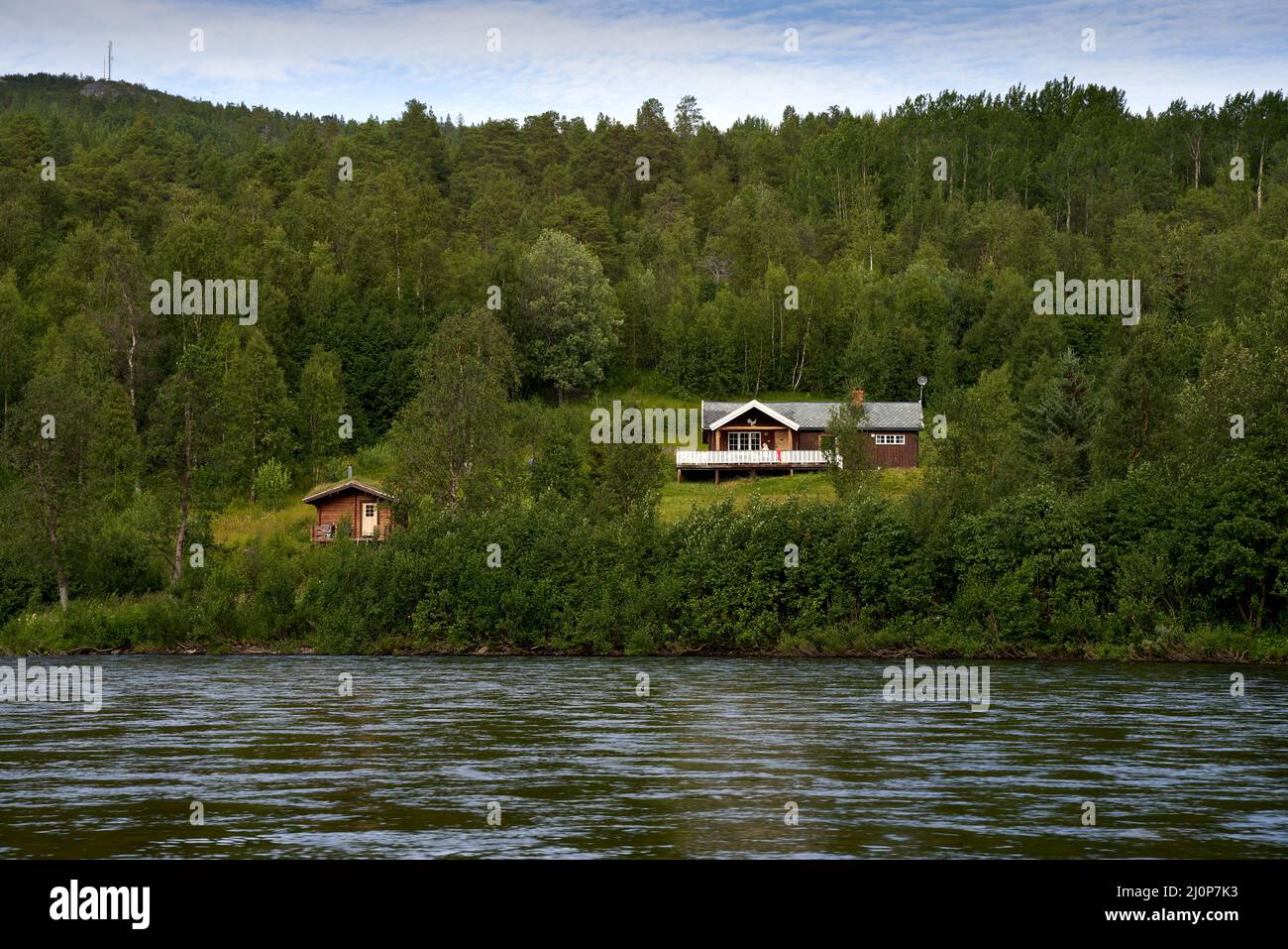 Wooden buildings surrounded by green dense trees on the Alta river ...