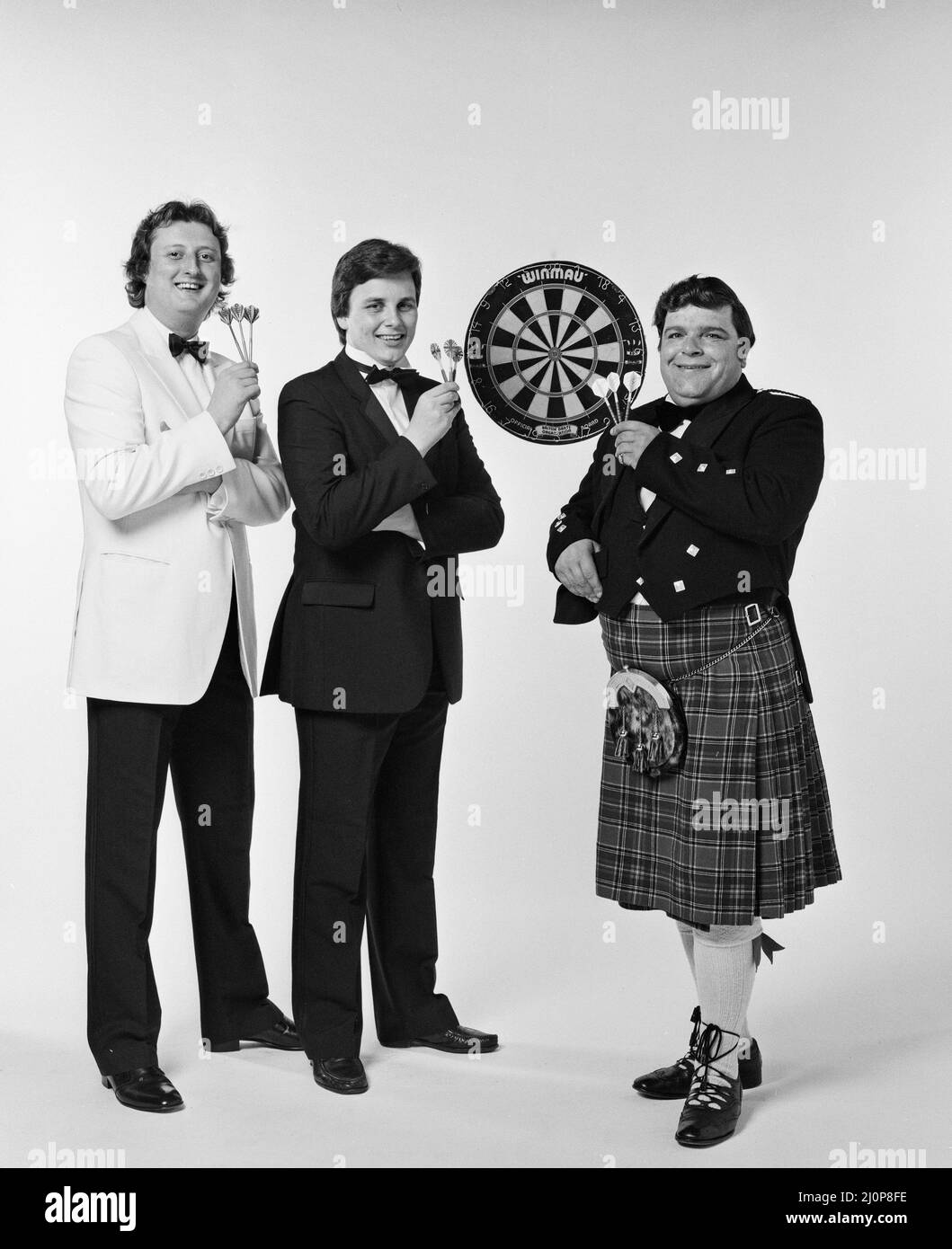 Well dressed British darts players pose for a photoshoot.Left to right ...
