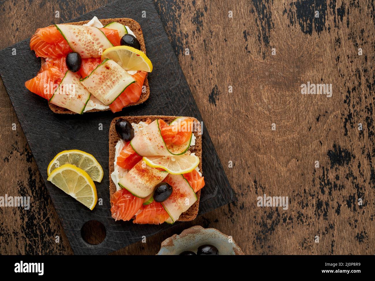 Smorrebrod - traditional Danish sandwiches. Black rye bread with salmon, cream cheese Stock ...