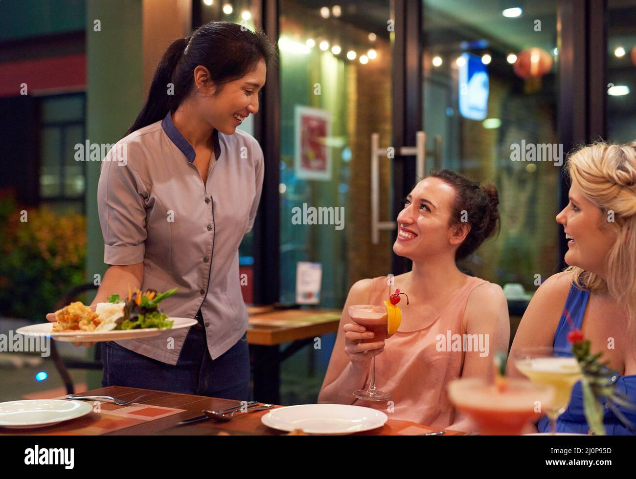 I hope you enjoy your meal. Cropped shot of a waitress serving ...