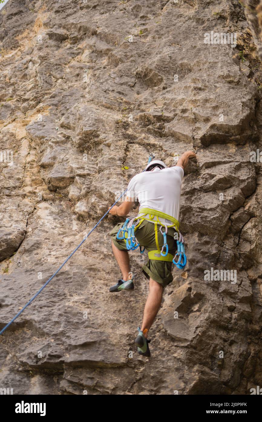 Handsome and fit young guy is climbing the high hill Stock Photo - Alamy