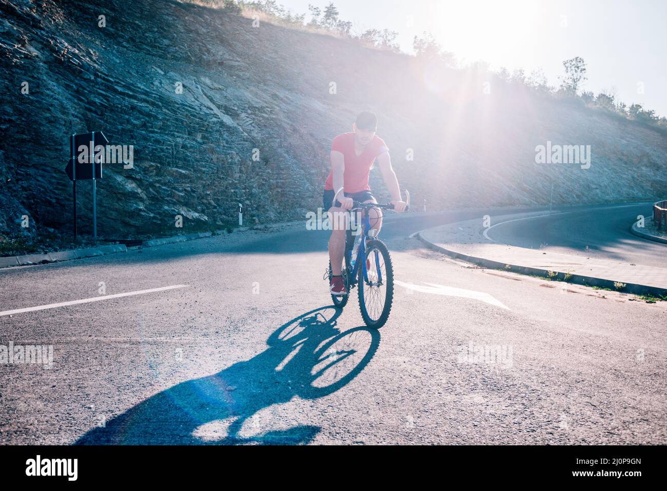 Fit male biker cyclist riding his bike cycle on an asphalt road at ...