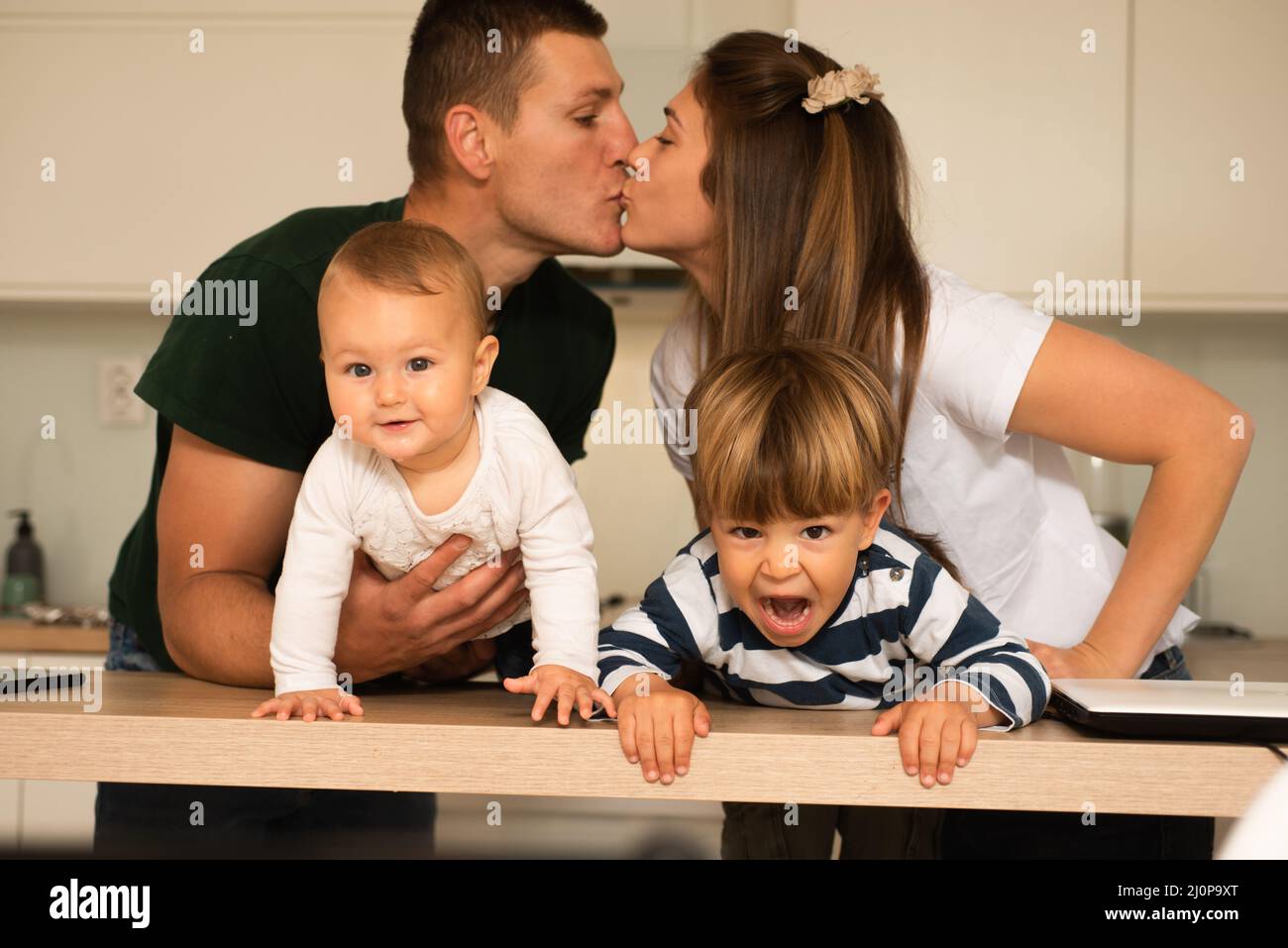 Perfect portrait of parents kissing while their son is screaming and ...