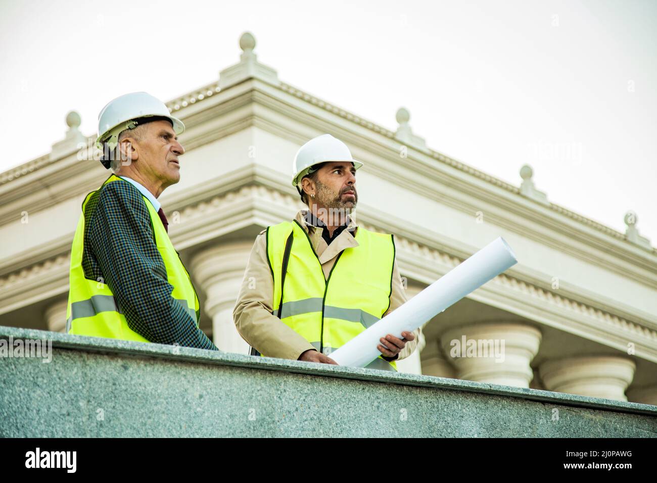 Two senior construction workers are looking and thinking Stock Photo ...