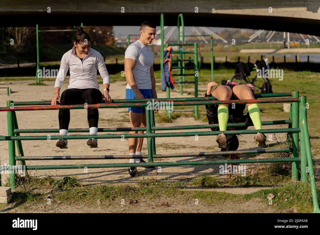 Two attractive and fit girls are exercising their abs with their coach ...