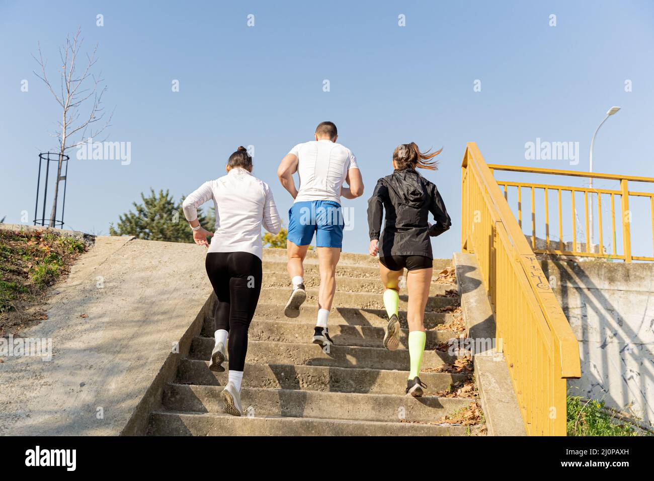 Three attractive and amazing fit friends are running up the stiars ...
