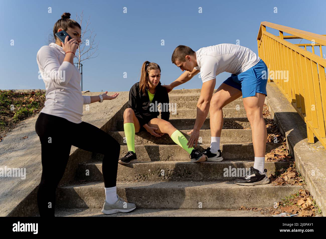 Two amazing and attractive fit friends are helping her Stock Photo - Alamy