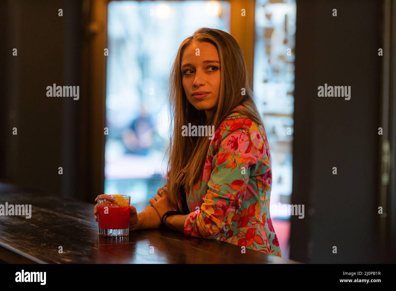 Attractive and beautiful young girl is standing alone on the bar Stock ...