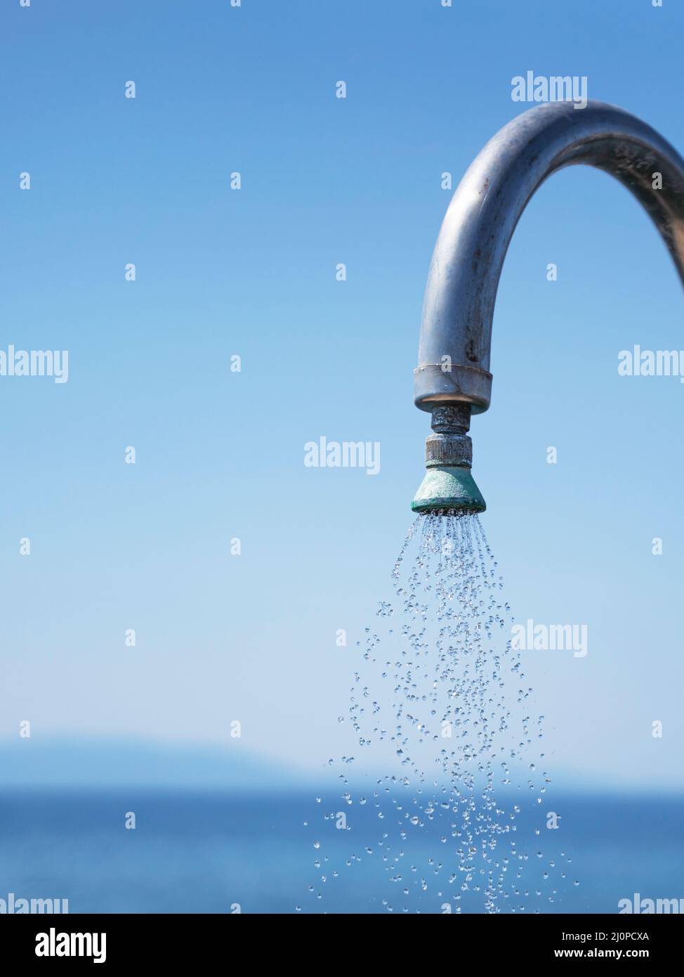 Shower with flowing Water against the backdrop of an azure sea ...