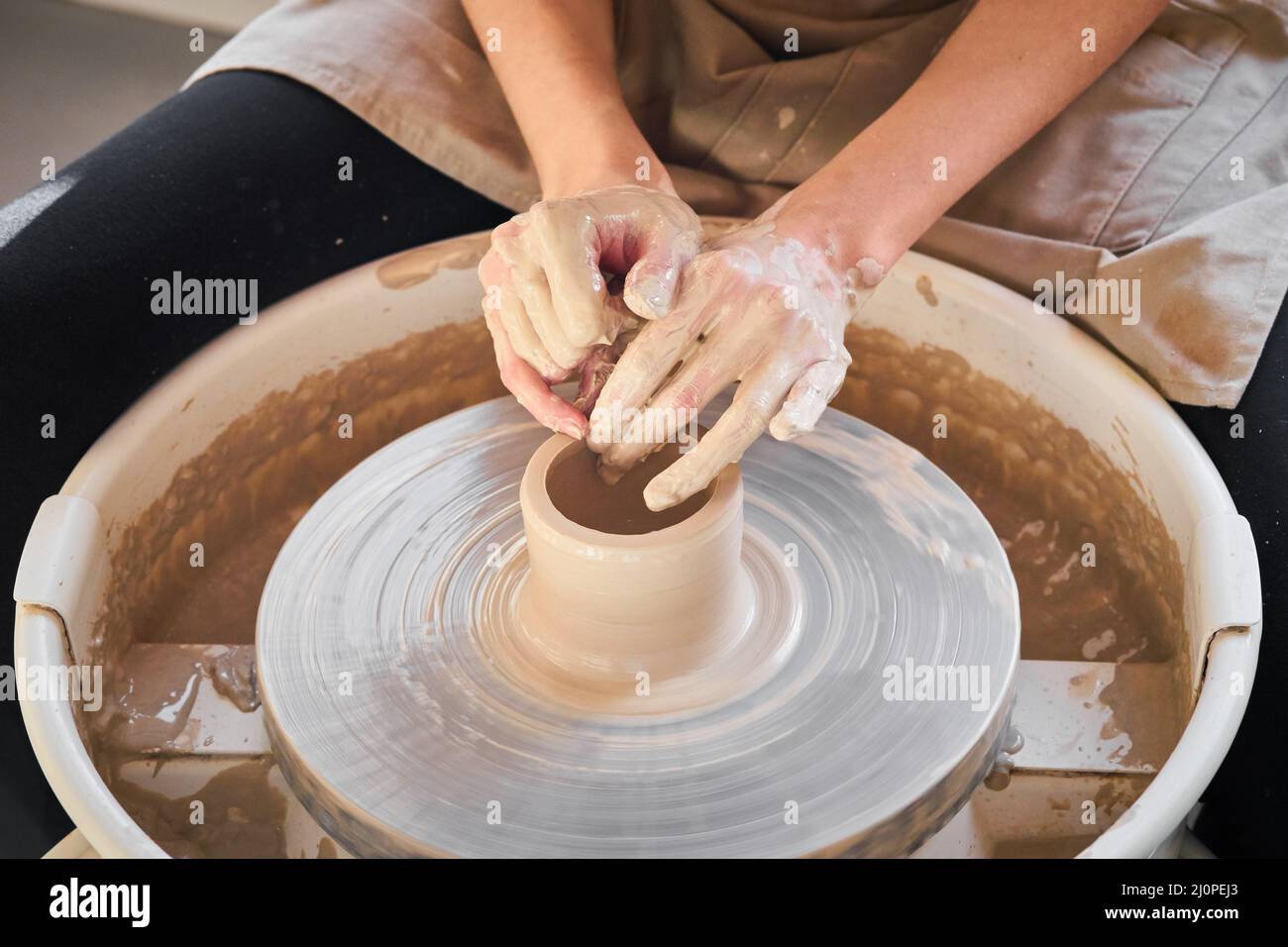 Woman making ceramic pottery on wheel, creation of ceramic ware ...