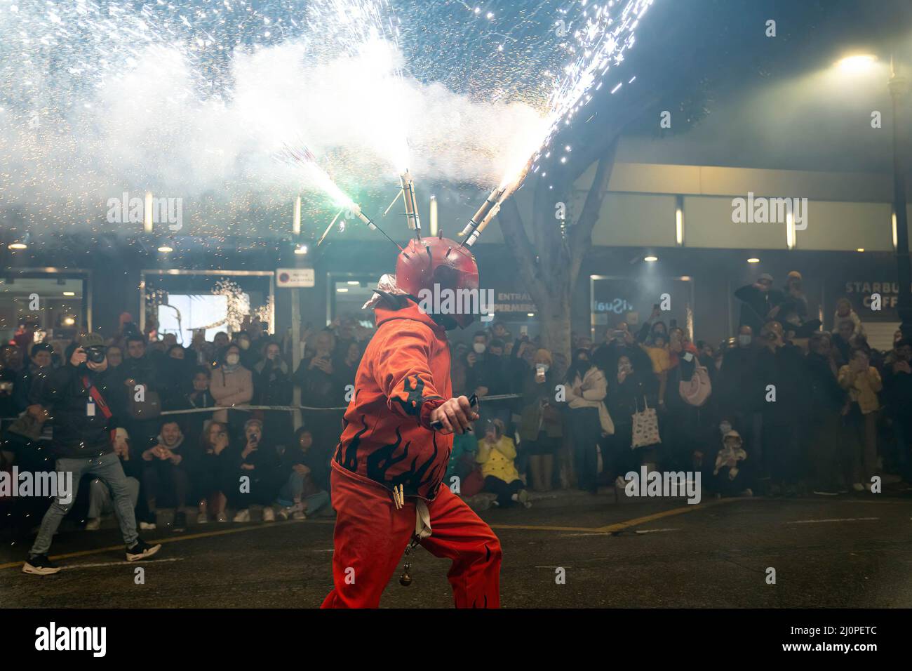 A person seen with fireworks on his helmet during the Parade of Fire in ...