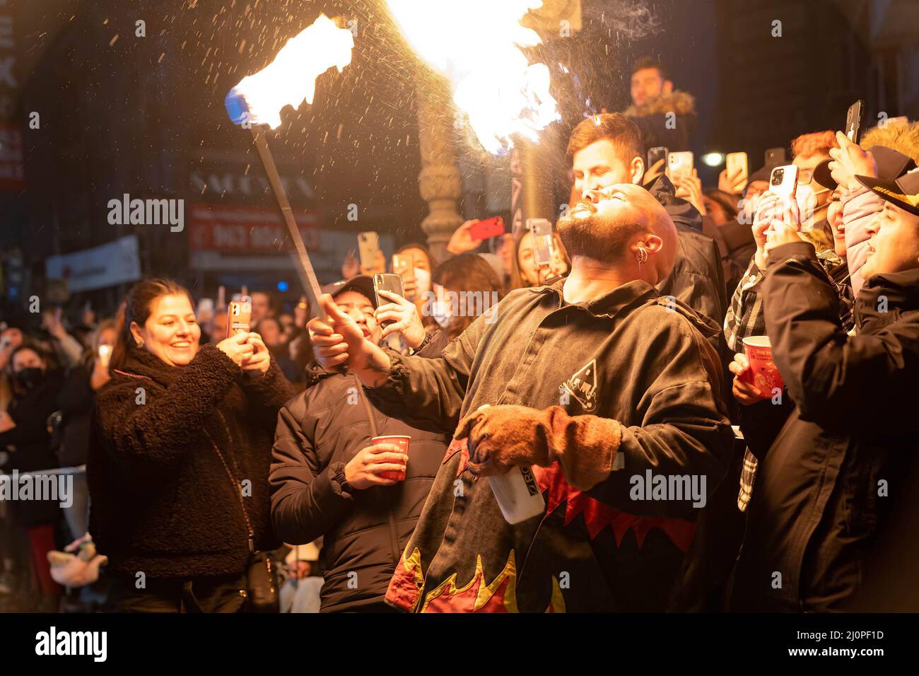 A man spits fire next to spectators during the Parade of Fire in ...