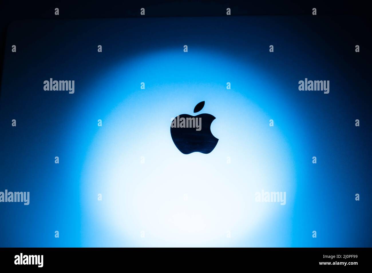 Spain, 03, 20, 2022. Macbook logo on blue metallic aluminium surface ...