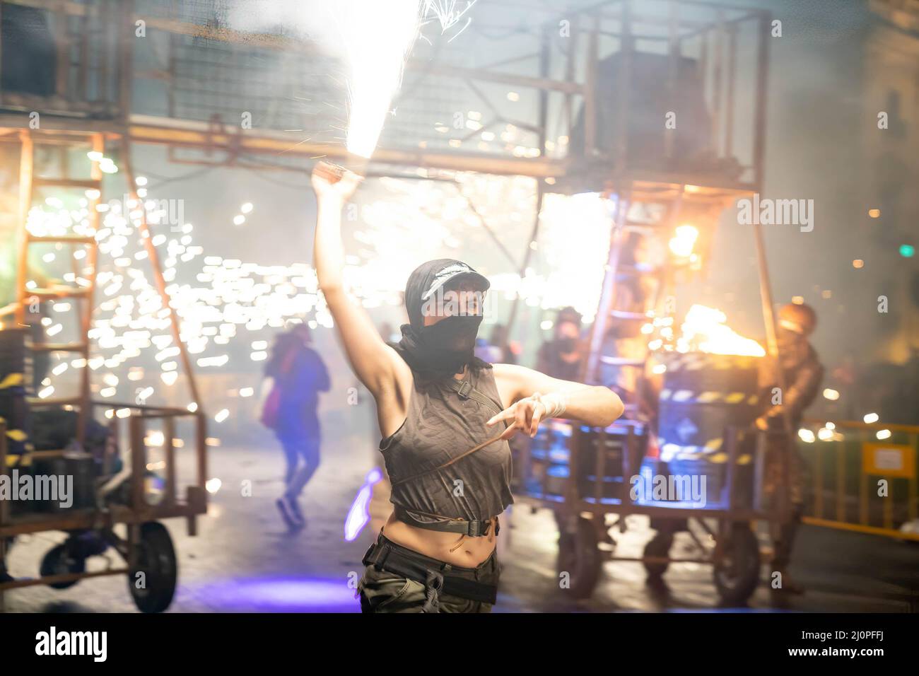 A woman holds fireworks during the Parade of Fire in Valencia. The ...