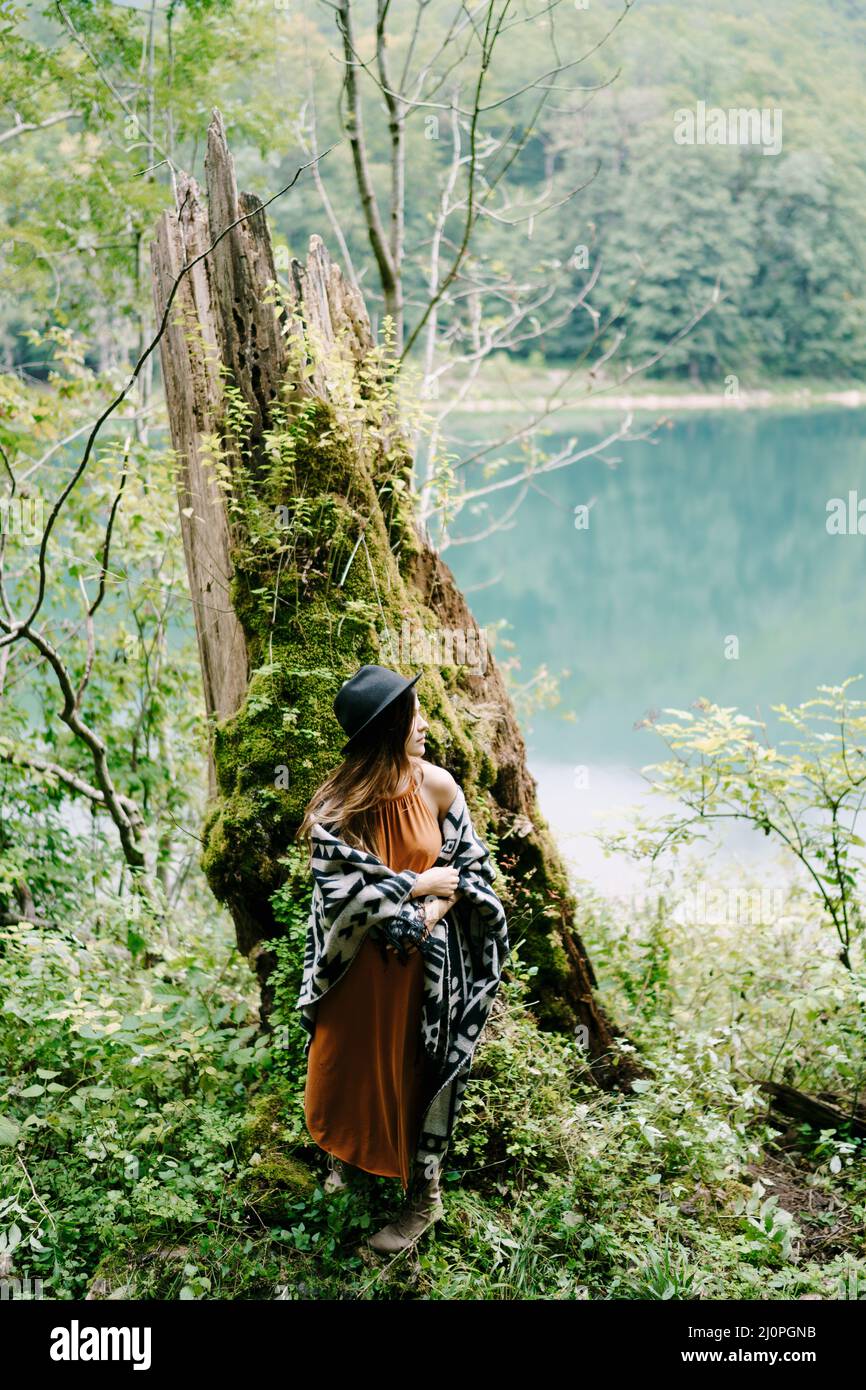 Woman stand near a tree overgrown with moss by the lake Stock Photo - Alamy