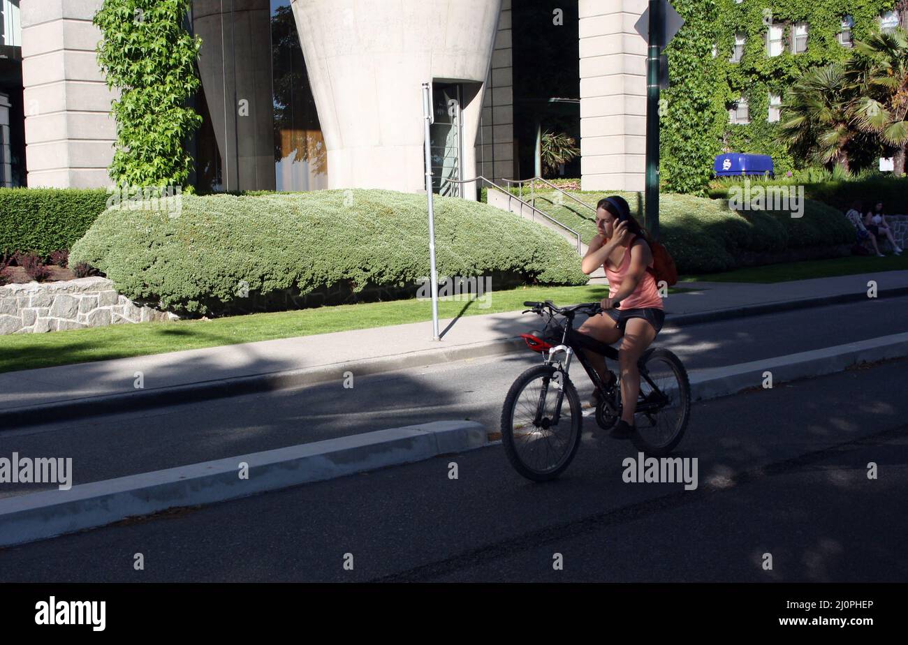 Young woman riding a bike in the street Stock Photo - Alamy
