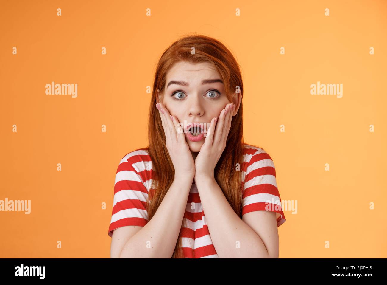 Close-up shocked speechless redhead woman, drop jaw gasping, touch ...
