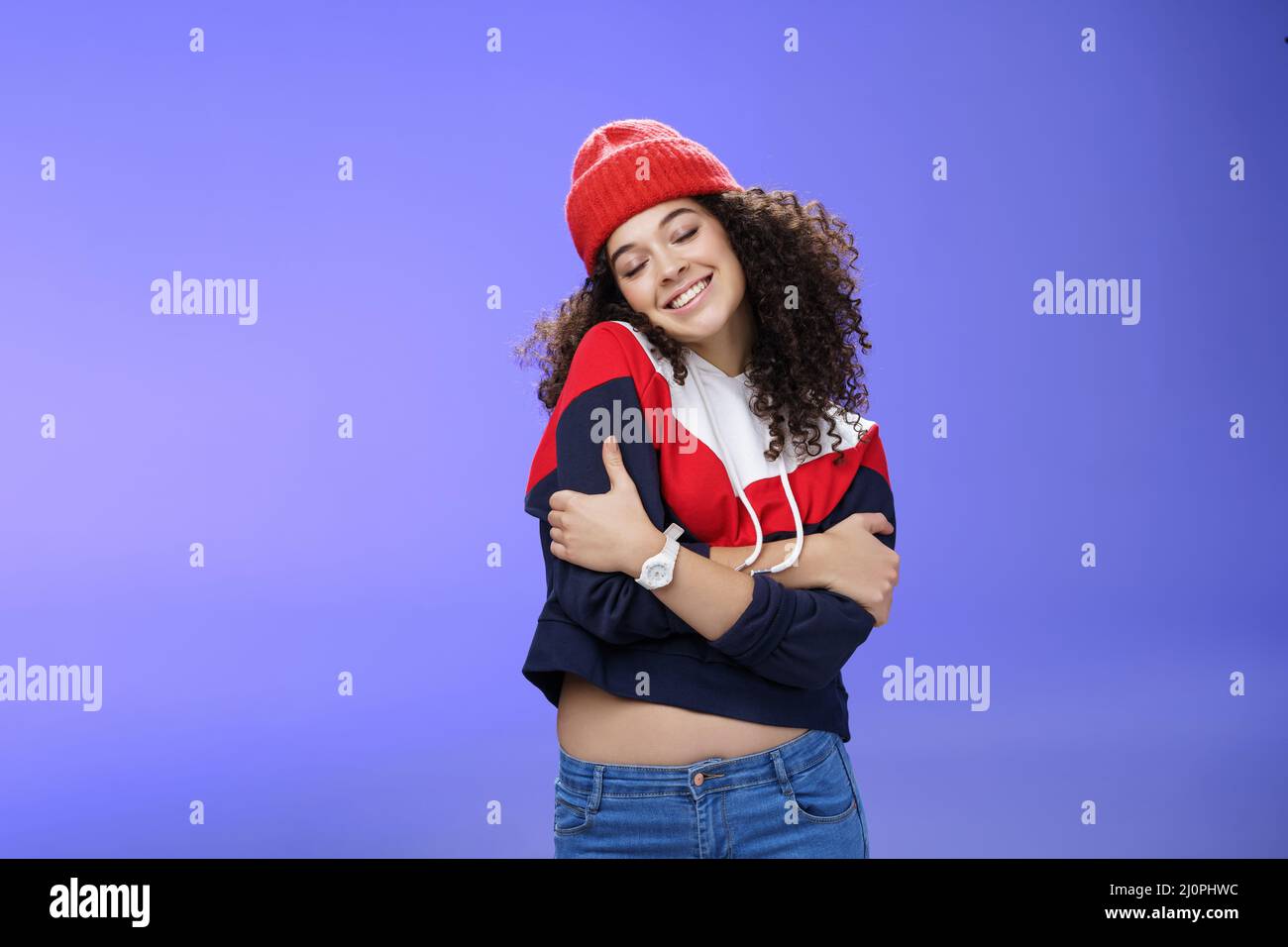 Sweet tender and sensual curly-haired woman in red stylish beanie ...