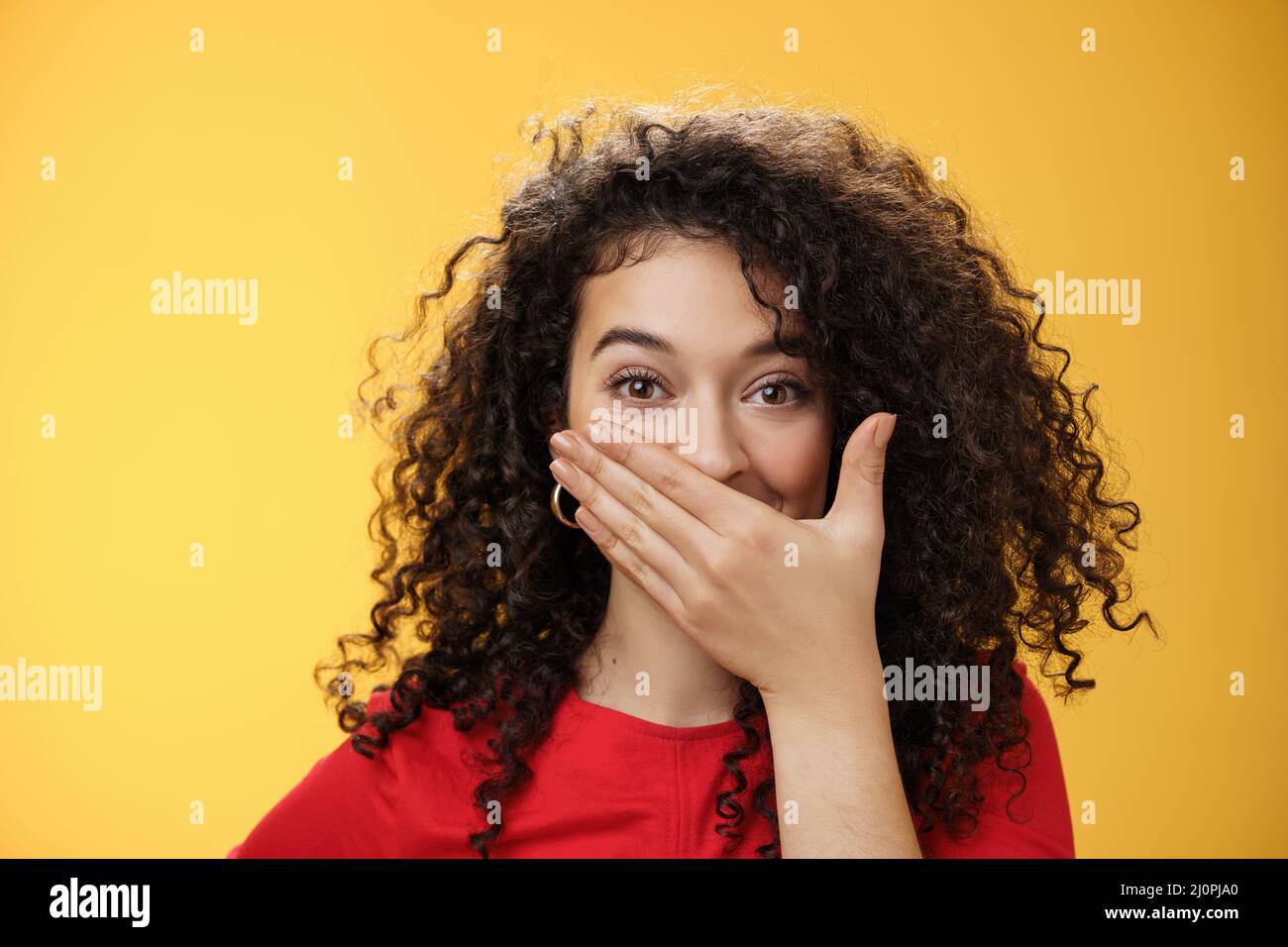 Close-up shot of excited and happy attractive female with curly hair ...