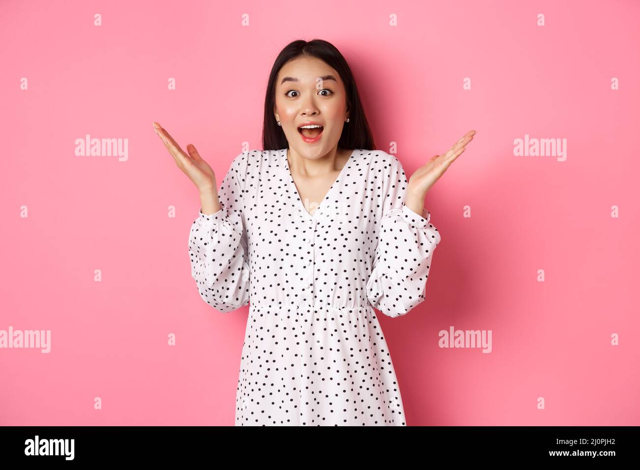 Happy and surprised asian woman rejoicing, spread hands and gasping ...