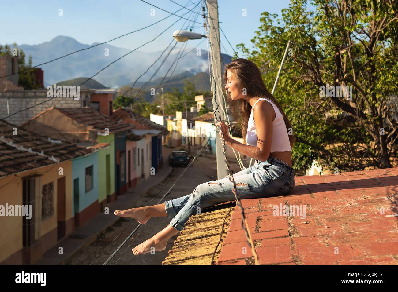Girl sitting on roof house hi-res stock photography and images - Alamy