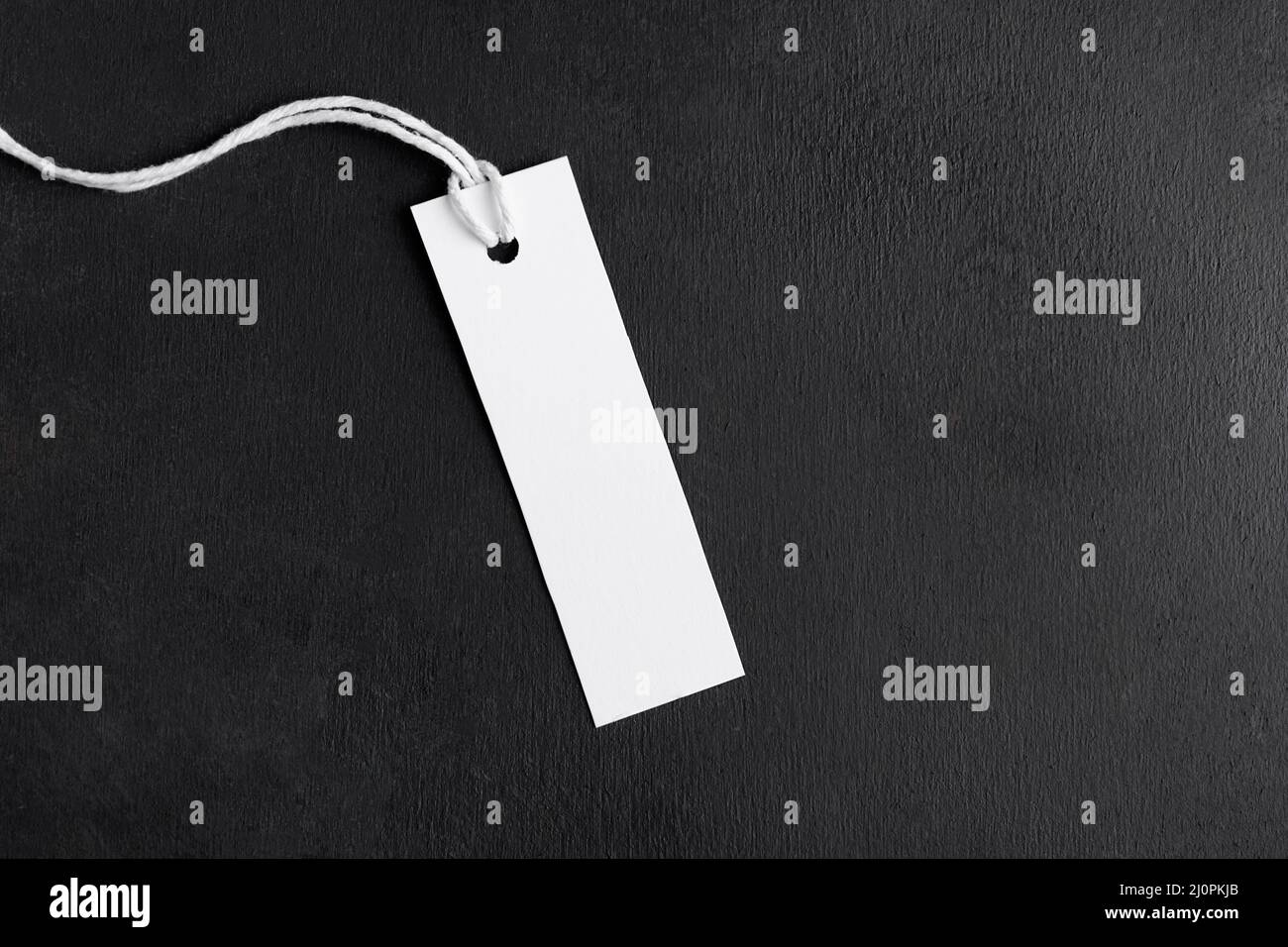 Rectangle strip white tag mockup with white cord, close up. Blank paper ...
