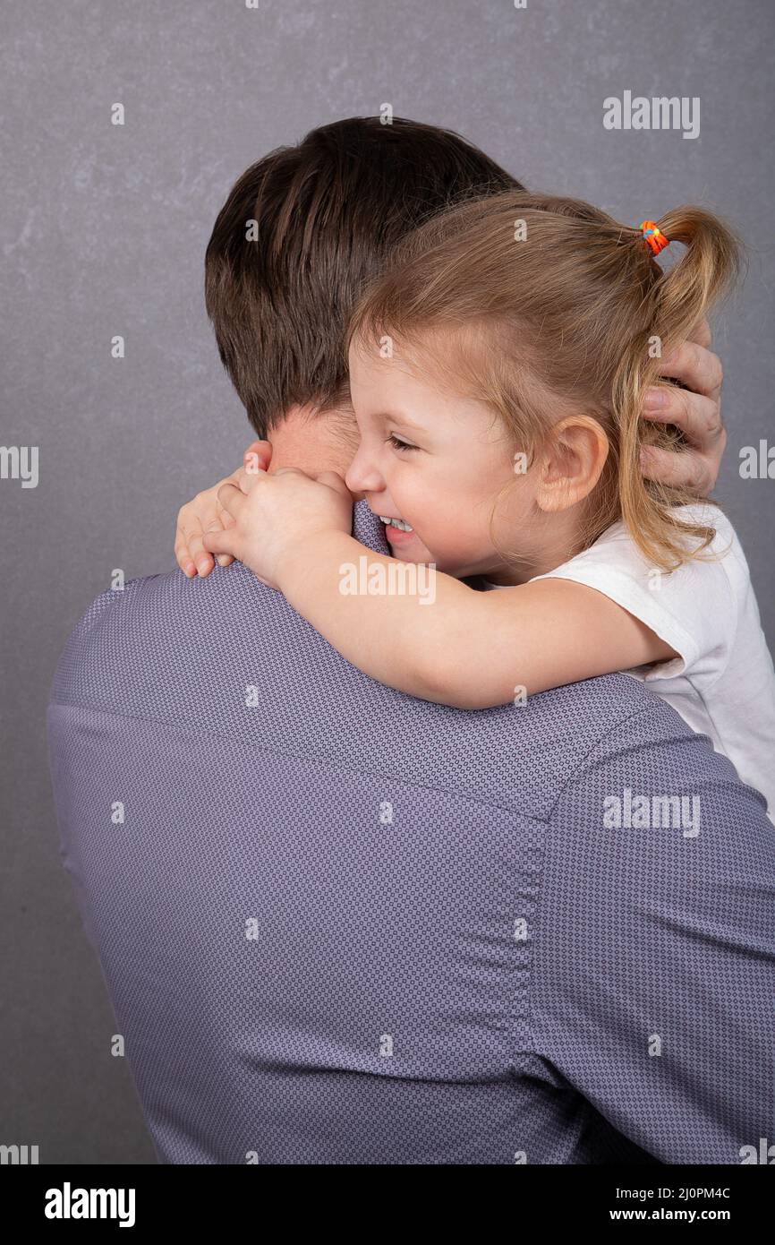 A little girl hugs her dad and smiles Stock Photo - Alamy
