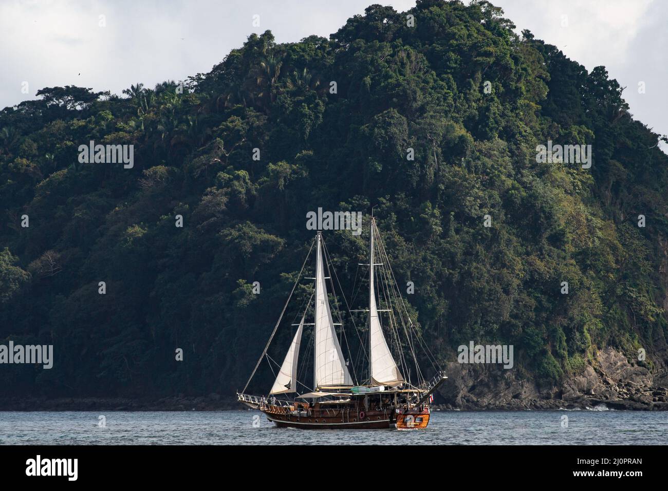Medieval ship sailing in the sea in front of an island with a large ...