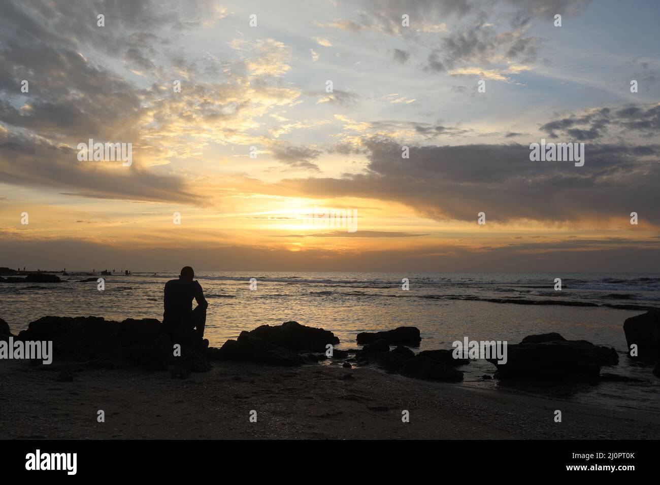Man alone in the sea lonely feeling sunset time Stock Photo - Alamy