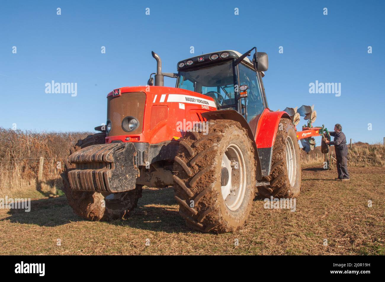 Farmer checking tractor with plough, Wales, UK Stock Photo - Alamy