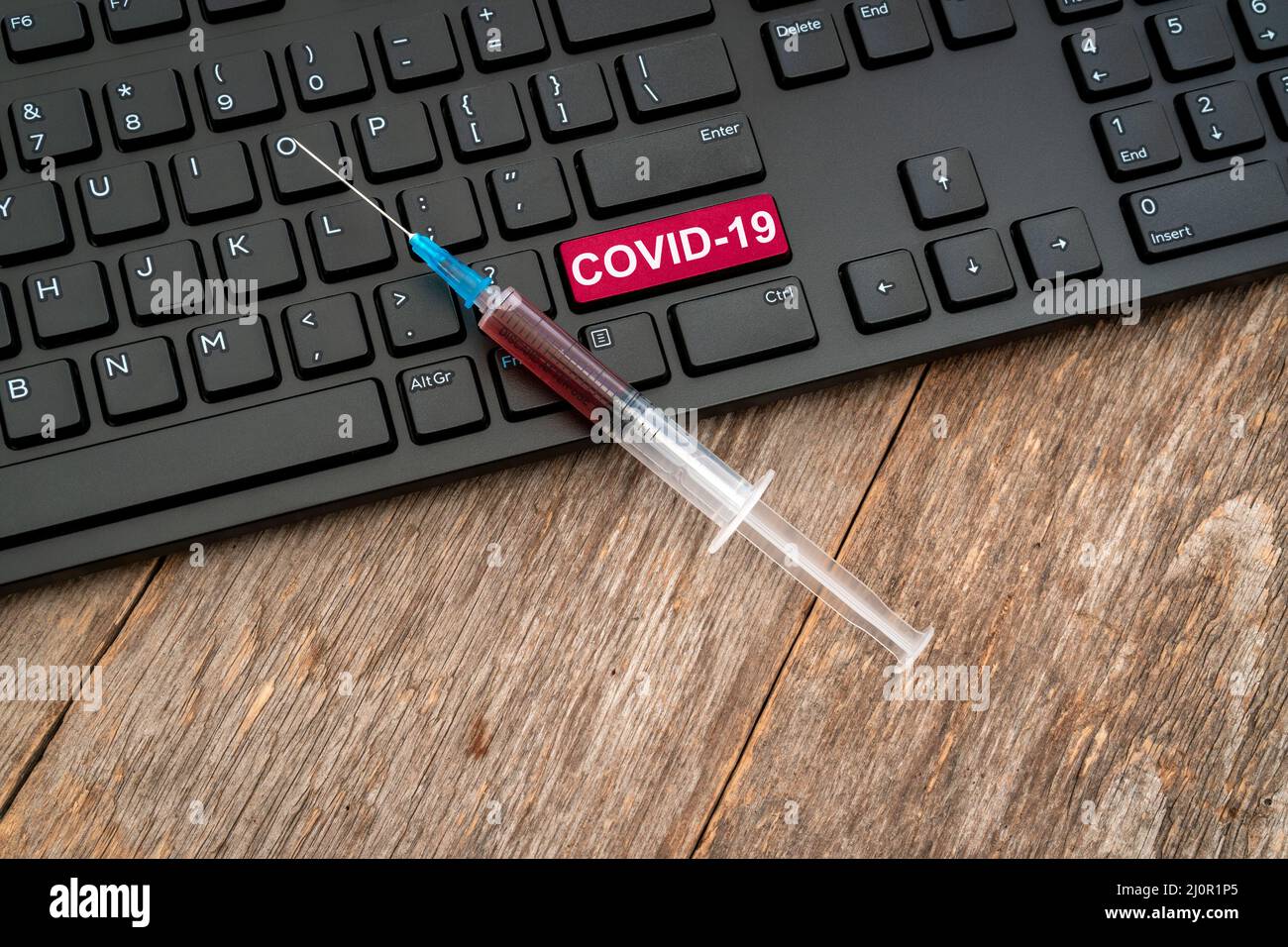 Syringe with vaccine on computer keyboard Stock Photo - Alamy