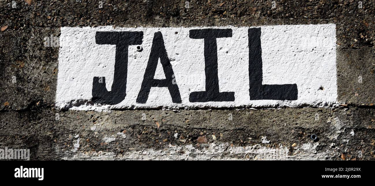 Old concrete and stone jail, is topped with a painted white and black ...