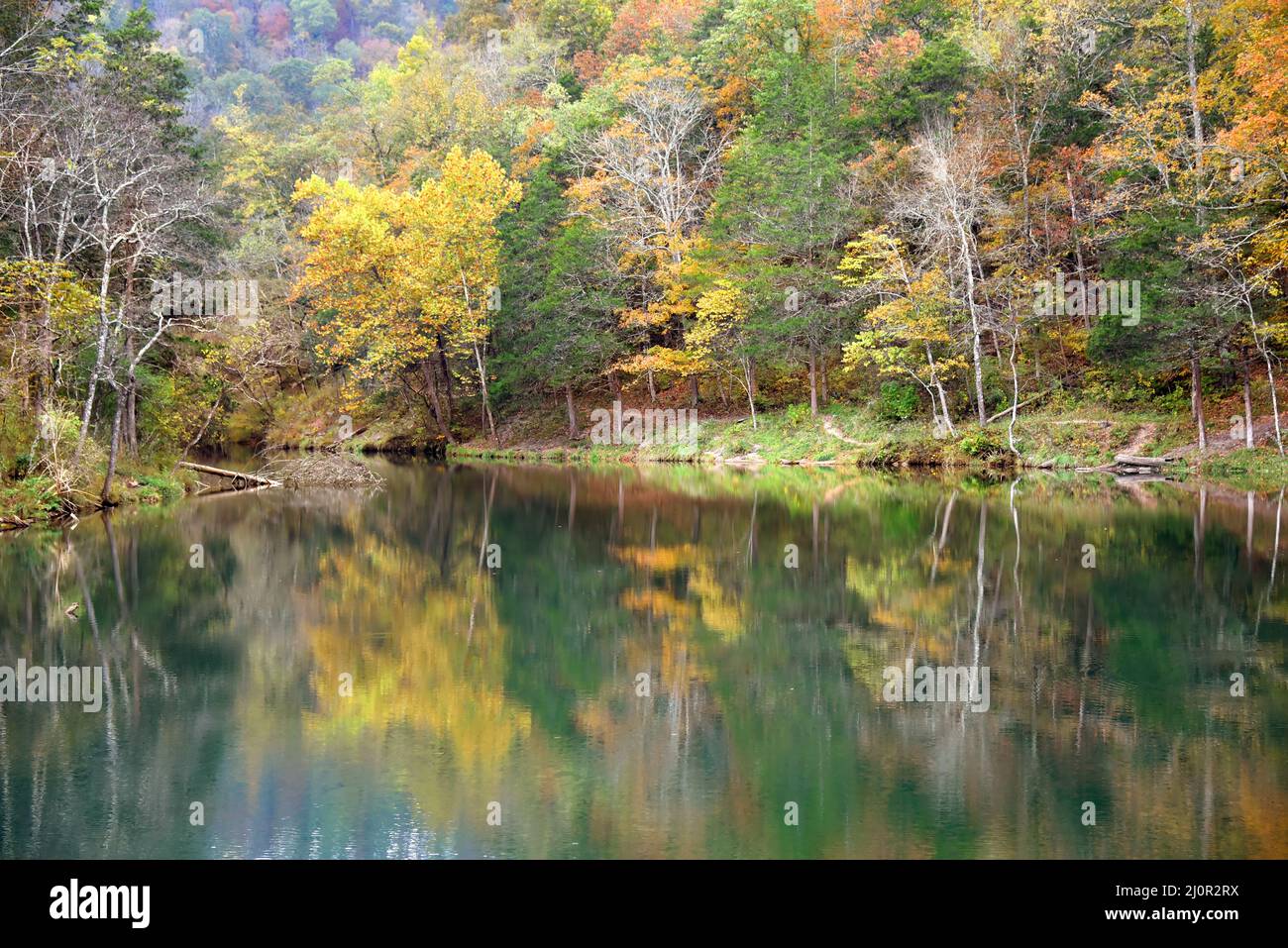 Unusual turquoise colored water shows reflection of Autumn color at ...