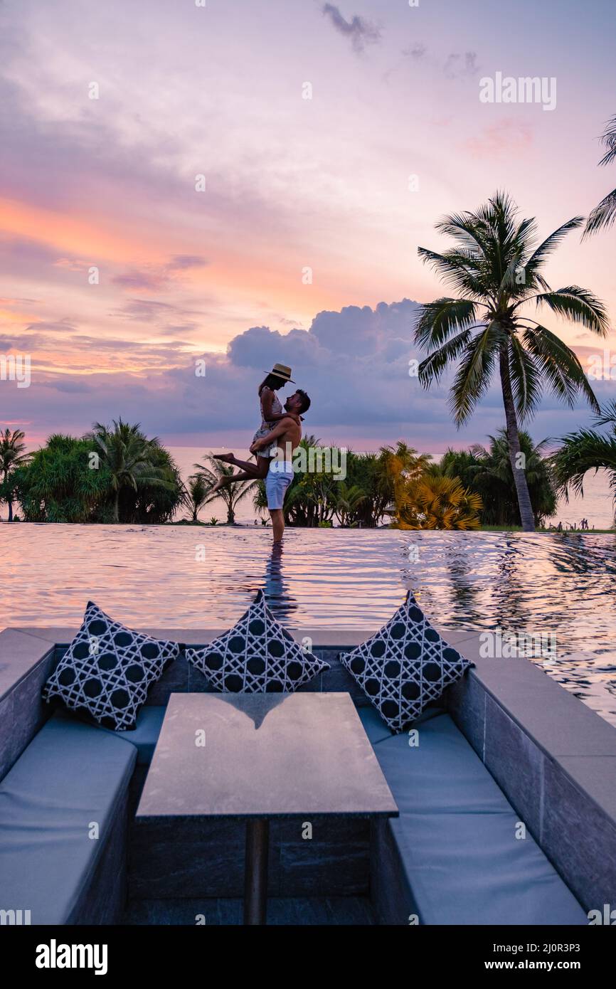 Couple watching sunset in infinity pool on a luxury vacation in ...