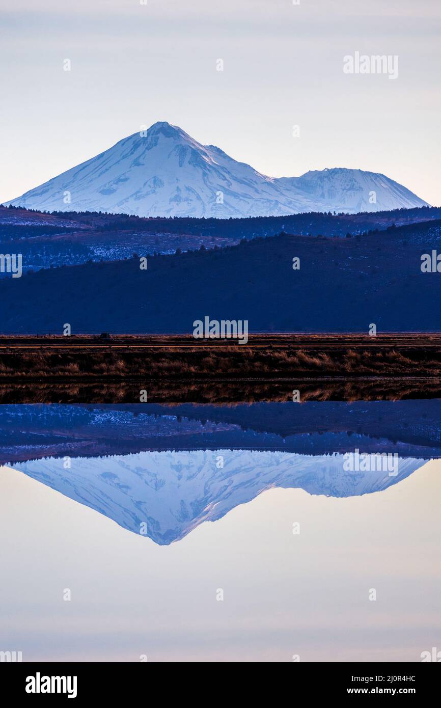 Vertical shot of the Mount Shasta with the reflection in the water in ...