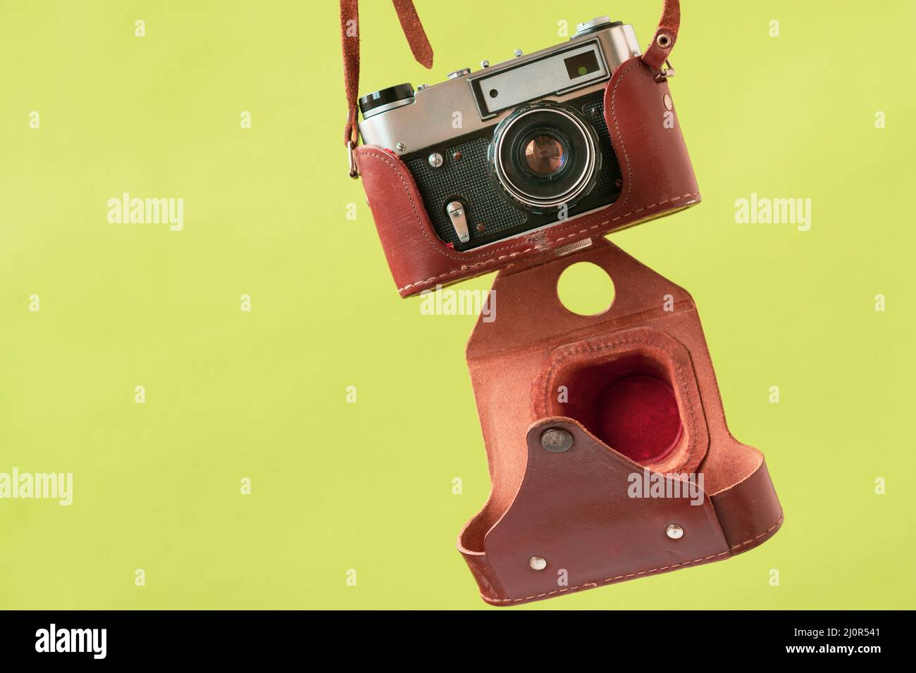Old film camera hanging on the green background Stock Photo - Alamy