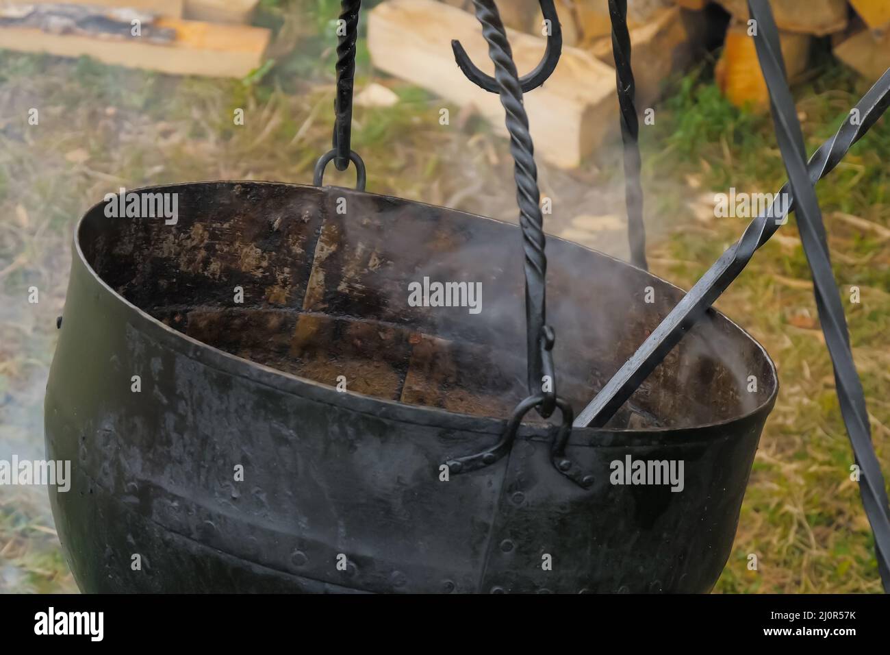 Preparing food in hanging pot over open fire - camping concept Stock ...