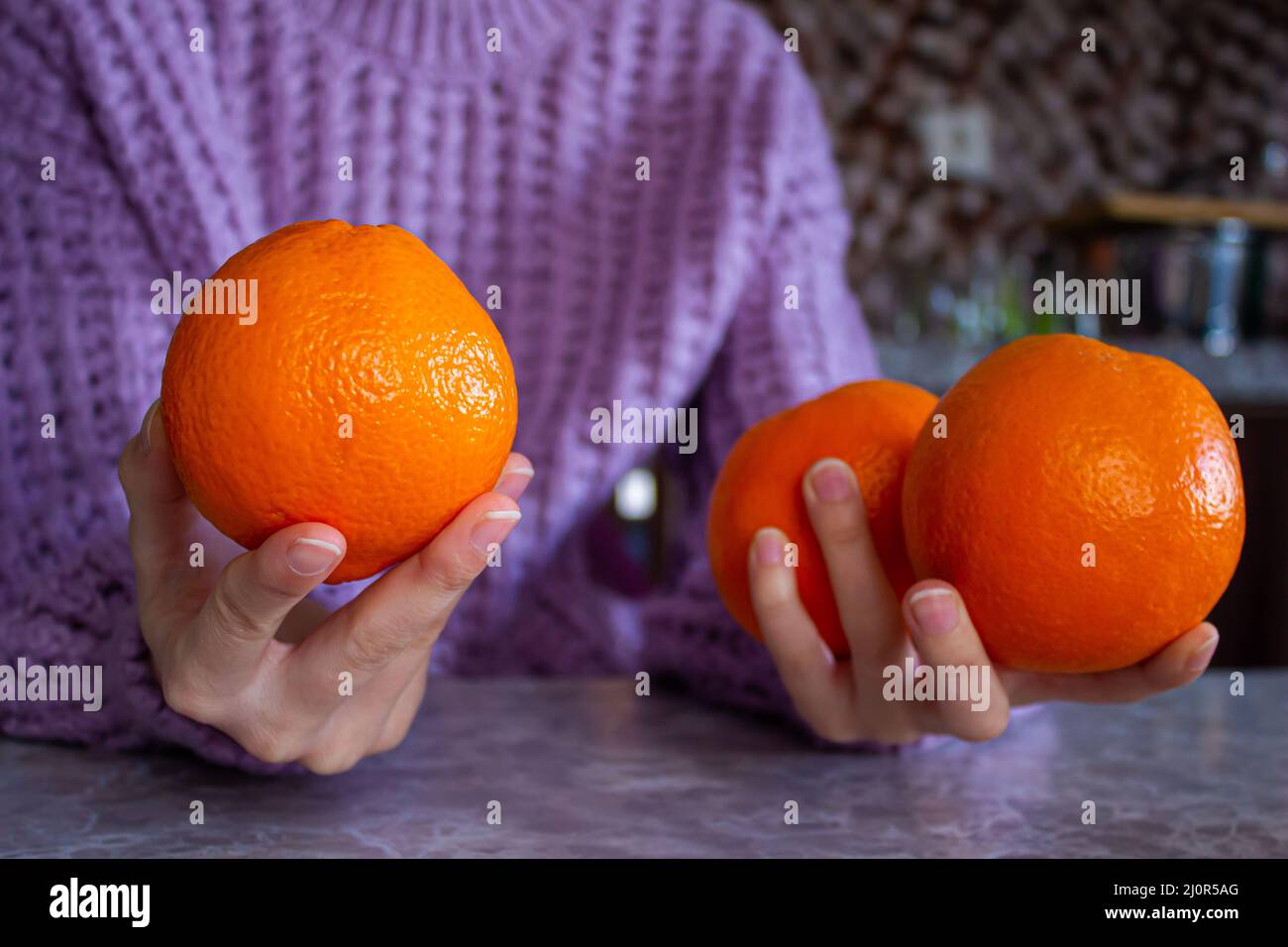 Closeup photo of woman holding orange fruit in hand. Healthy eating ...