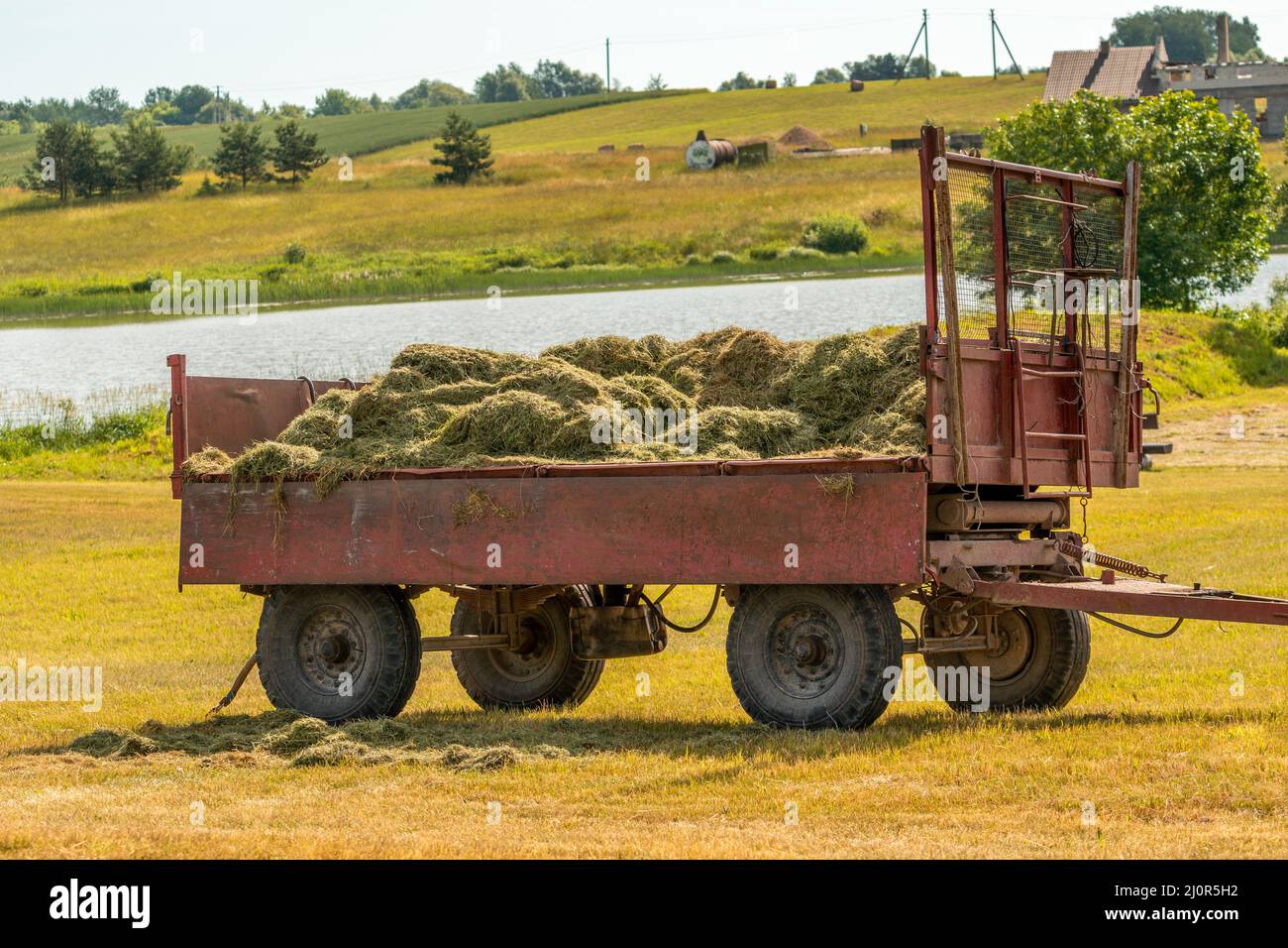 Tractor trailer with mowed green grass in a public park Stock Photo - Alamy