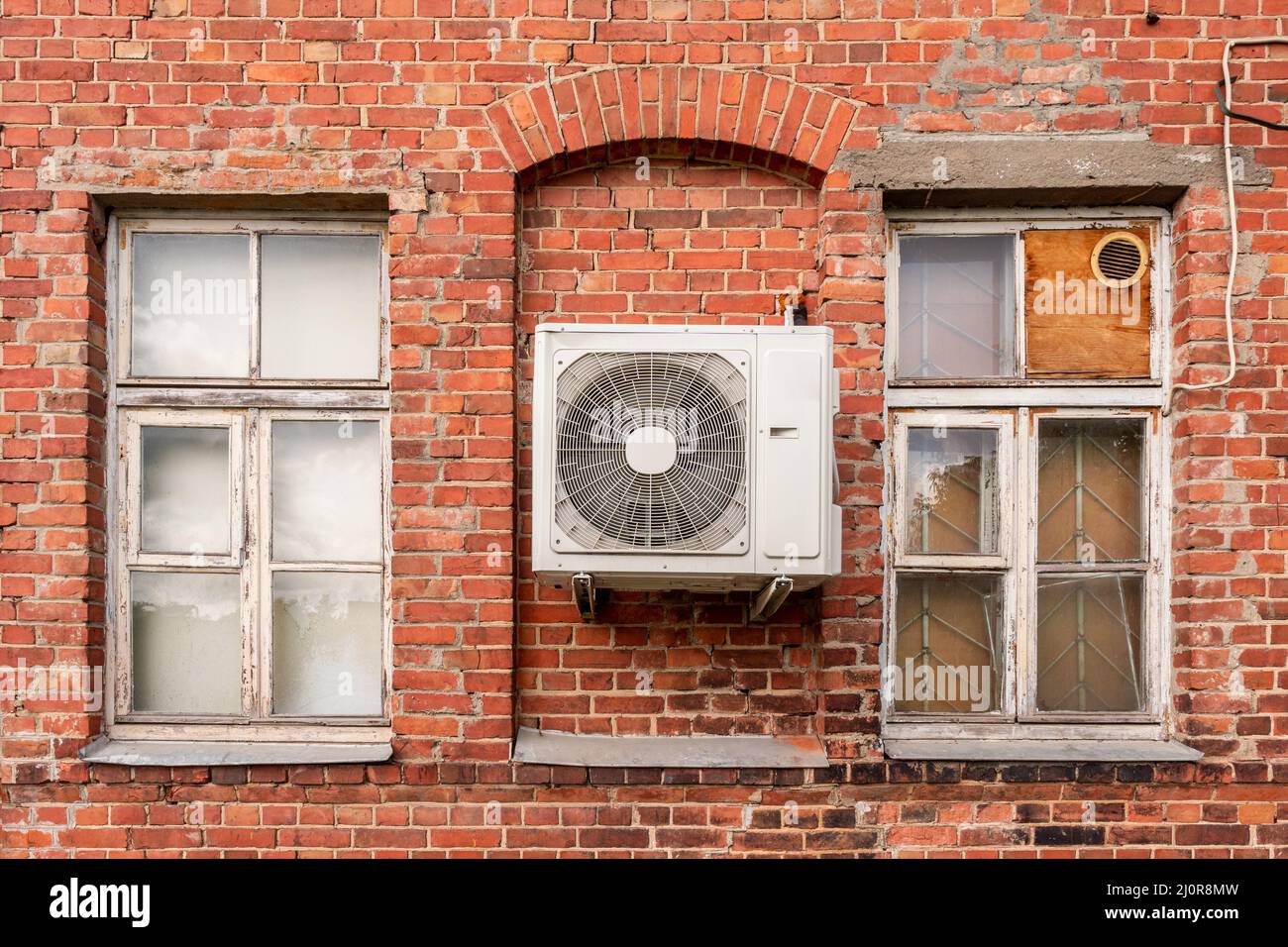 Air conditioning unit on the facade of a old brick house Stock Photo ...